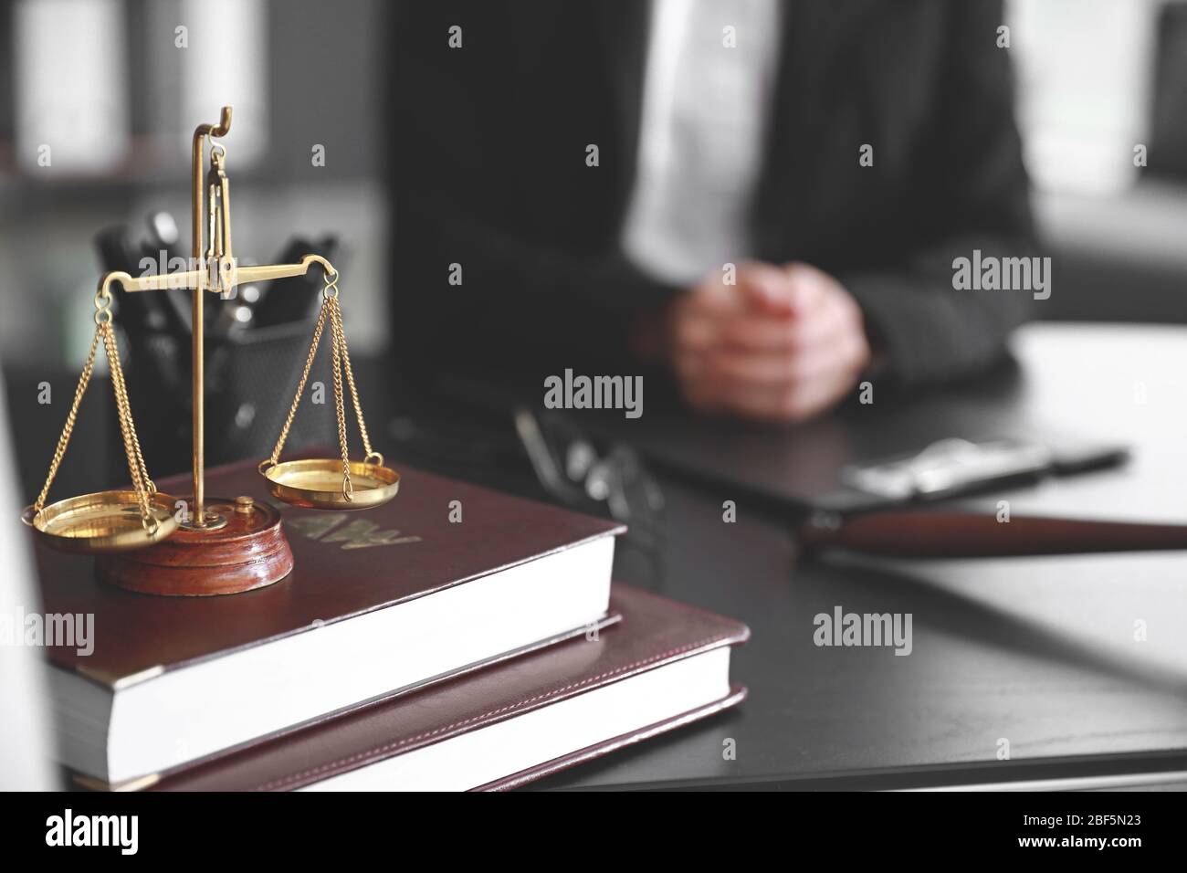 Scales of justice with law books on table of notary public in office ...