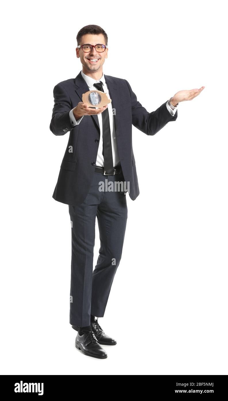 Happy male bank manager with piggy bank showing something on white ...