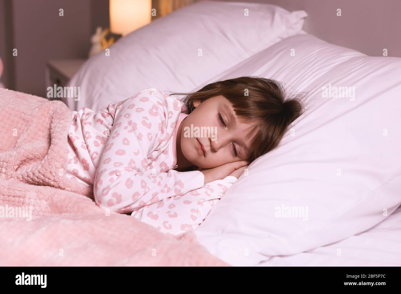 Cute little girl sleeping in bed at night Stock Photo - Alamy