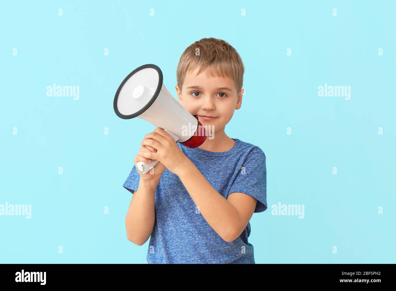 Cute little boy with megaphone on color background Stock Photo - Alamy