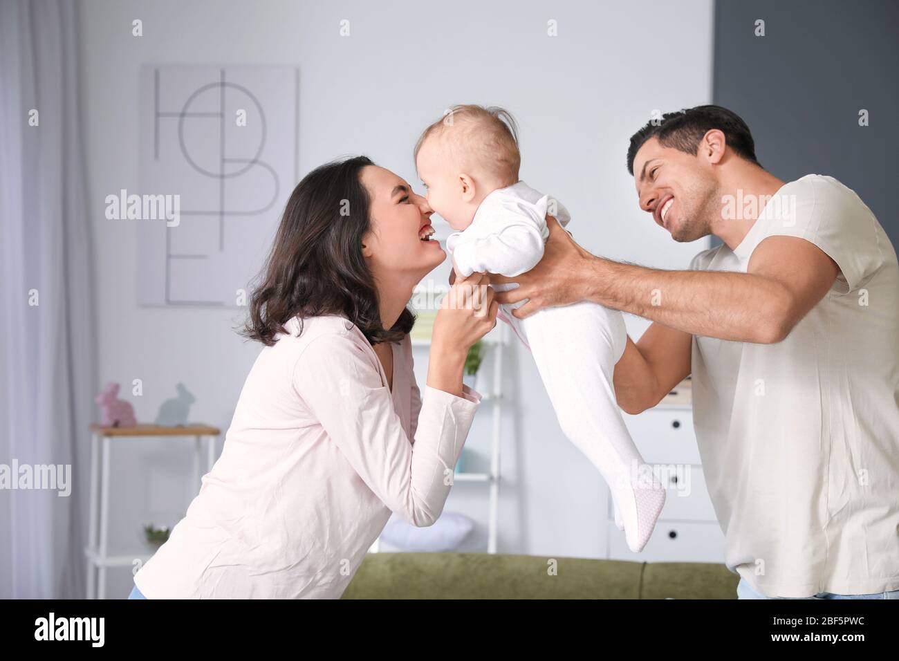 Cute baby with parents at home Stock Photo - Alamy