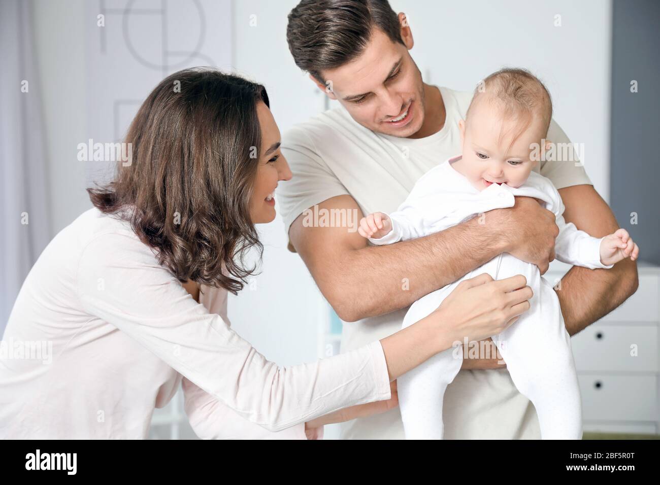 Cute baby with parents at home Stock Photo - Alamy