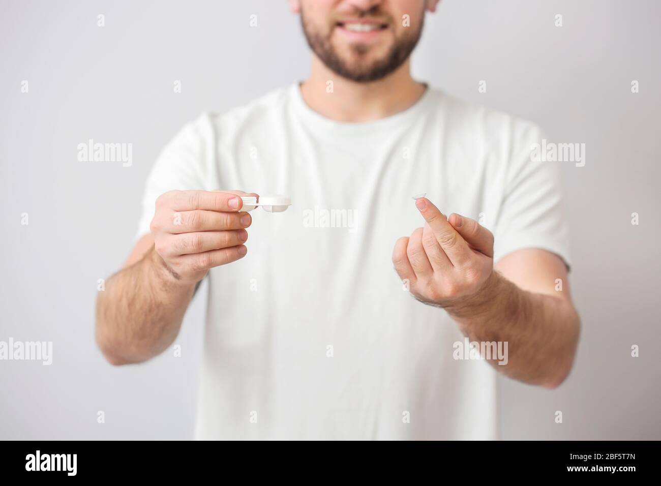 Handsome man with contact lenses on grey background Stock Photo - Alamy