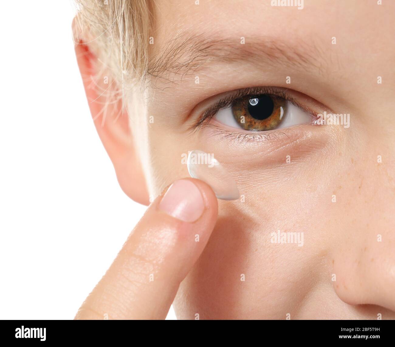 Little boy putting in contact lens on white background, closeup Stock ...