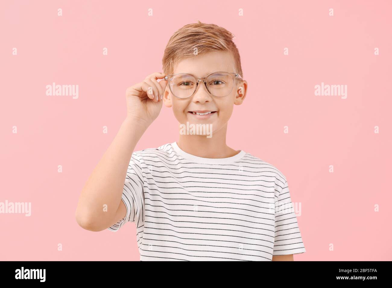 Cute little boy with eyeglasses on color background Stock Photo - Alamy