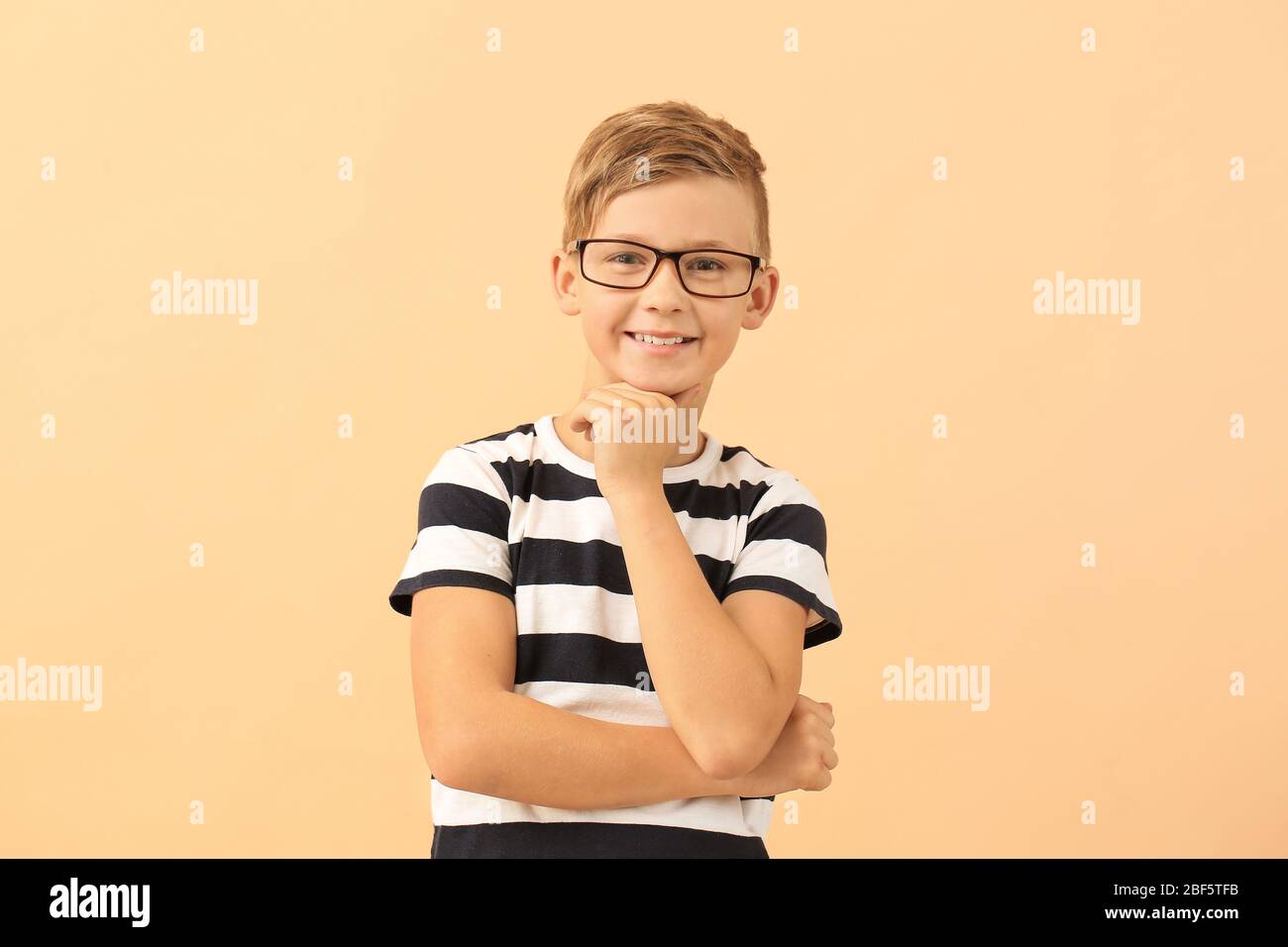 Cute little boy with eyeglasses on color background Stock Photo - Alamy