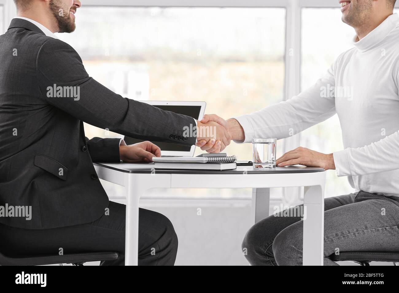 Bank manager and man shaking hands in office Stock Photo - Alamy