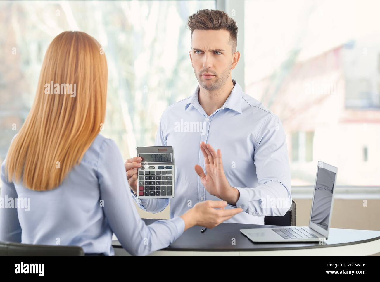 Bank manager working with displeased man in office Stock Photo - Alamy