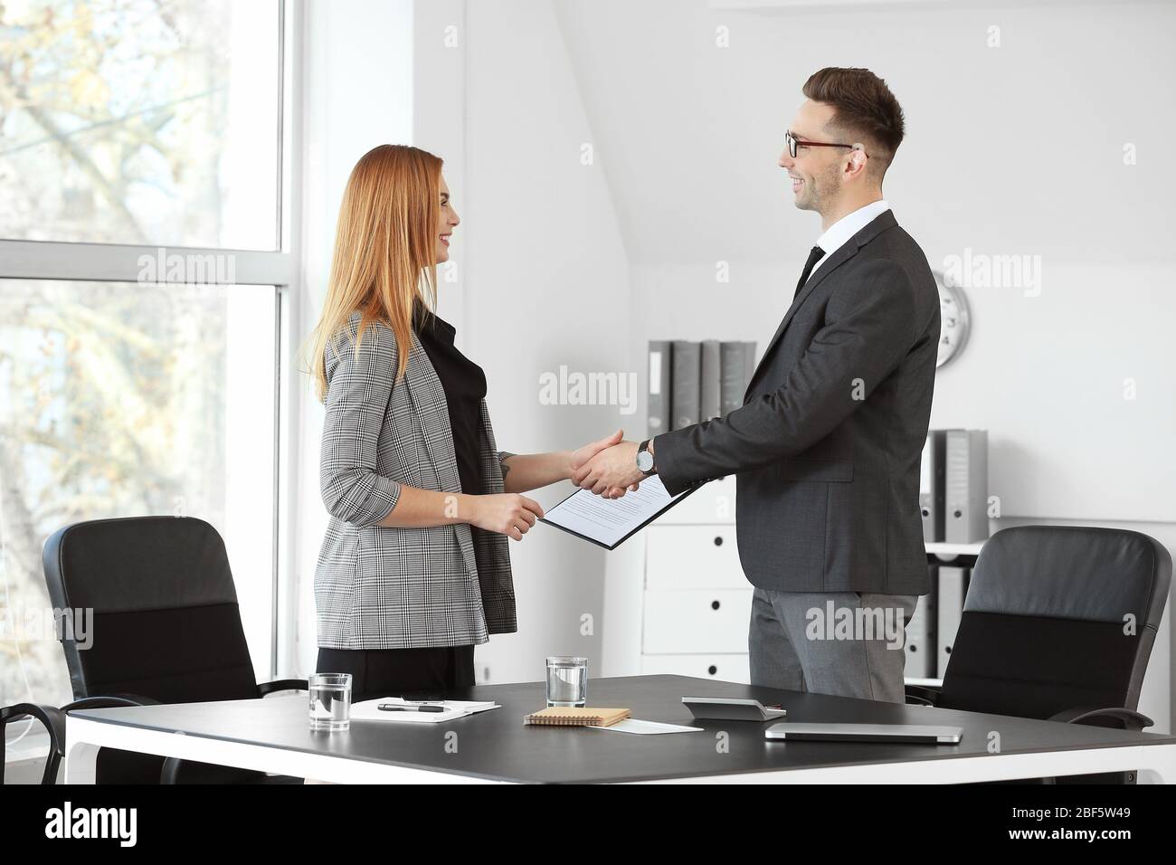 Bank manager and woman shaking hands in office Stock Photo - Alamy