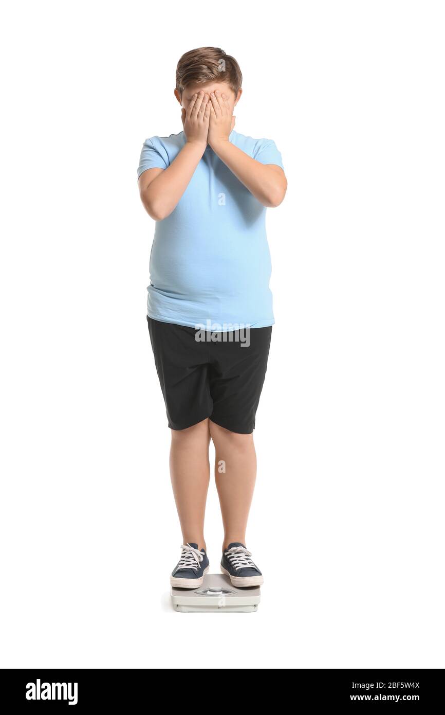 Overweight boy standing on scales against white background Stock Photo ...