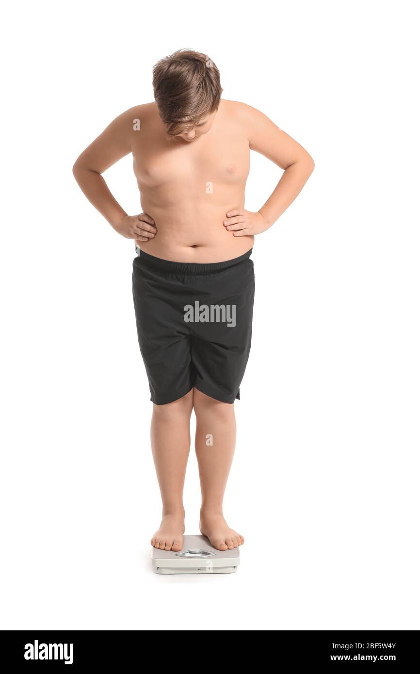 Overweight boy standing on scales against white background Stock Photo ...