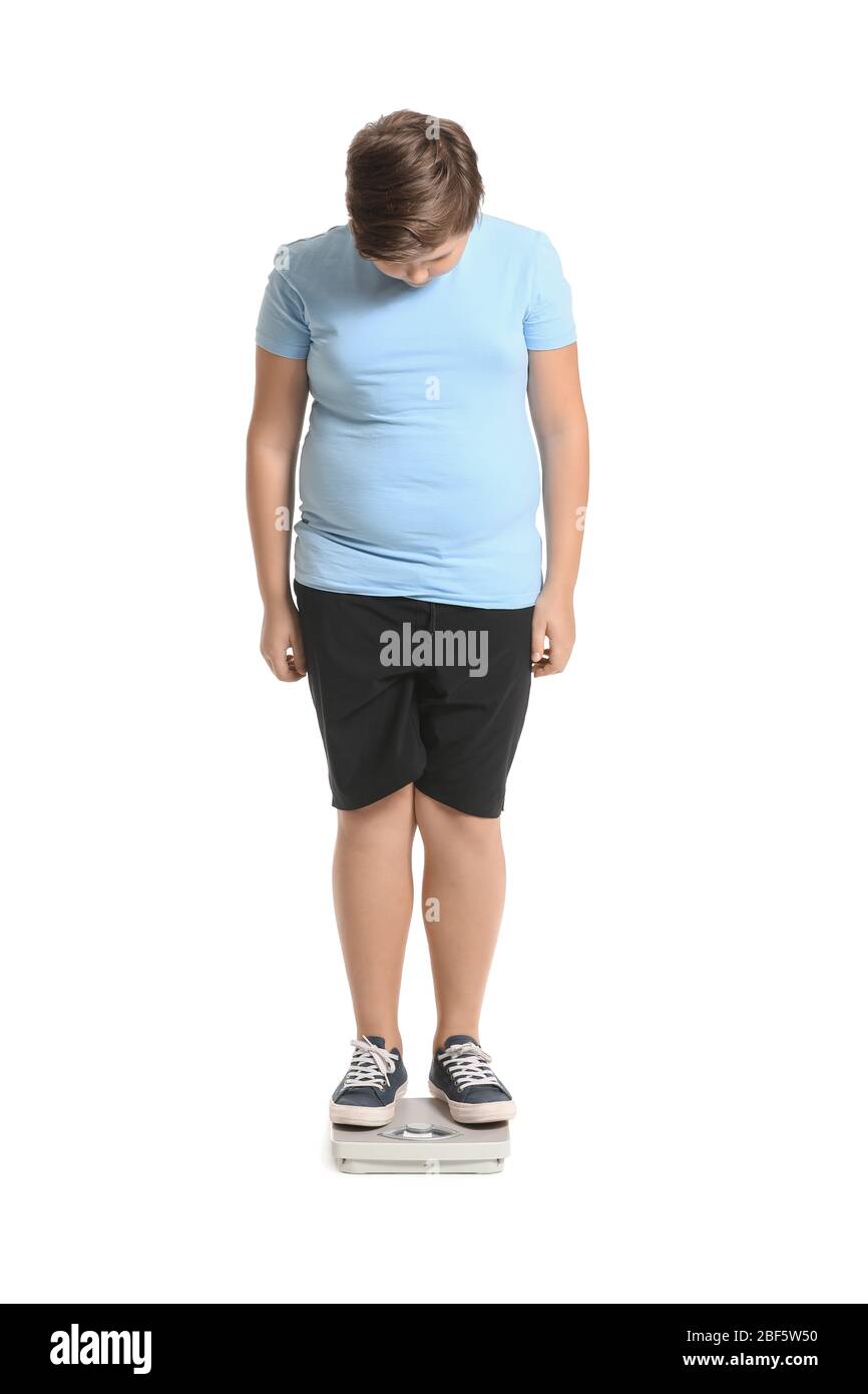 Overweight boy standing on scales against white background Stock Photo ...