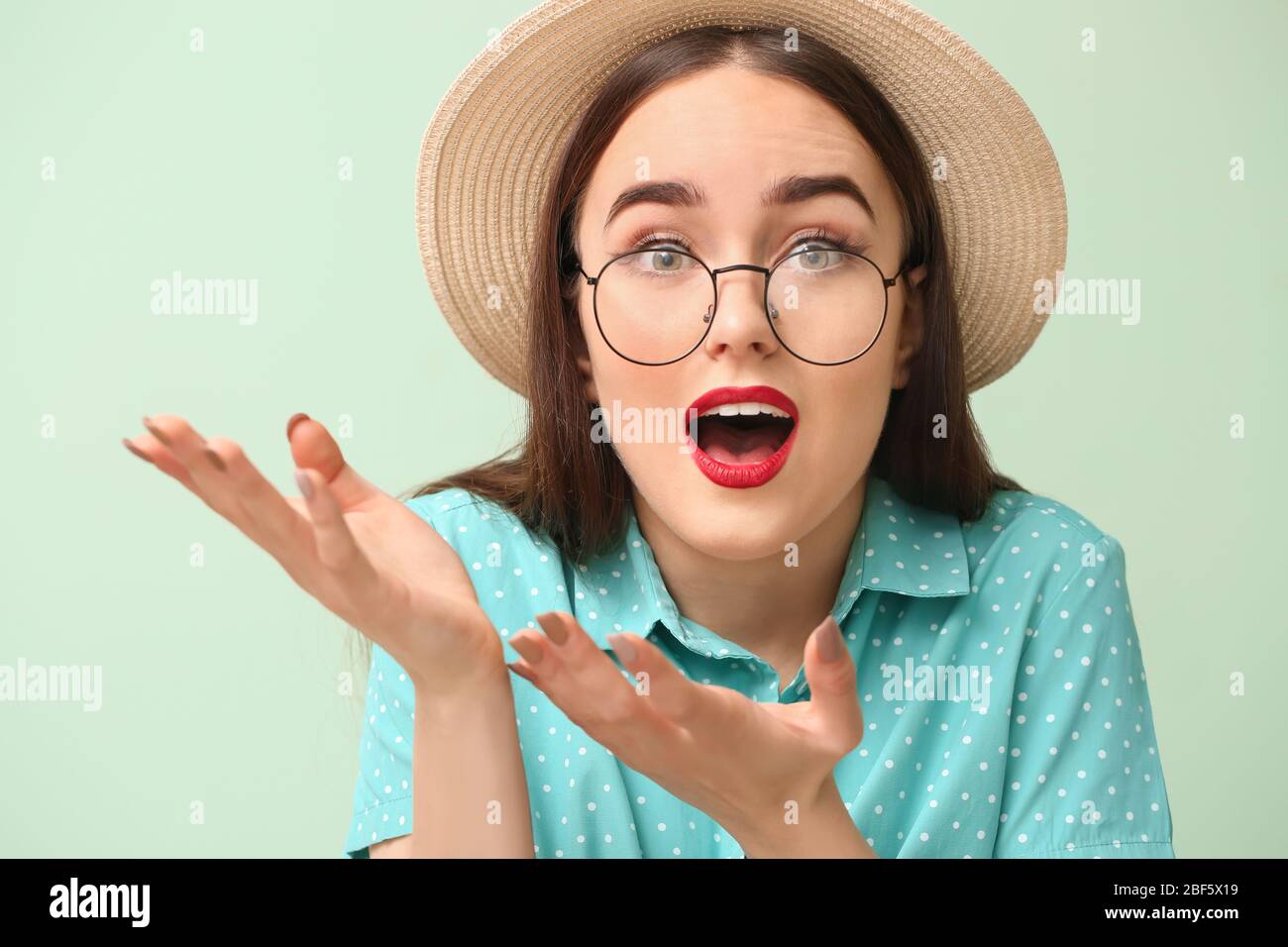 Confused young woman on color background Stock Photo - Alamy