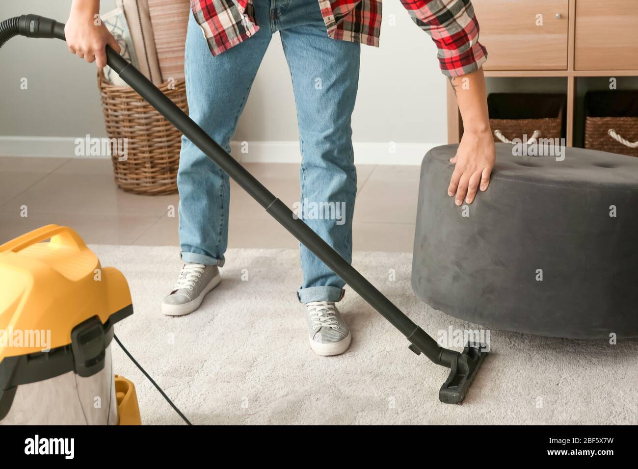 Young Asian man hoovering floor at home Stock Photo - Alamy