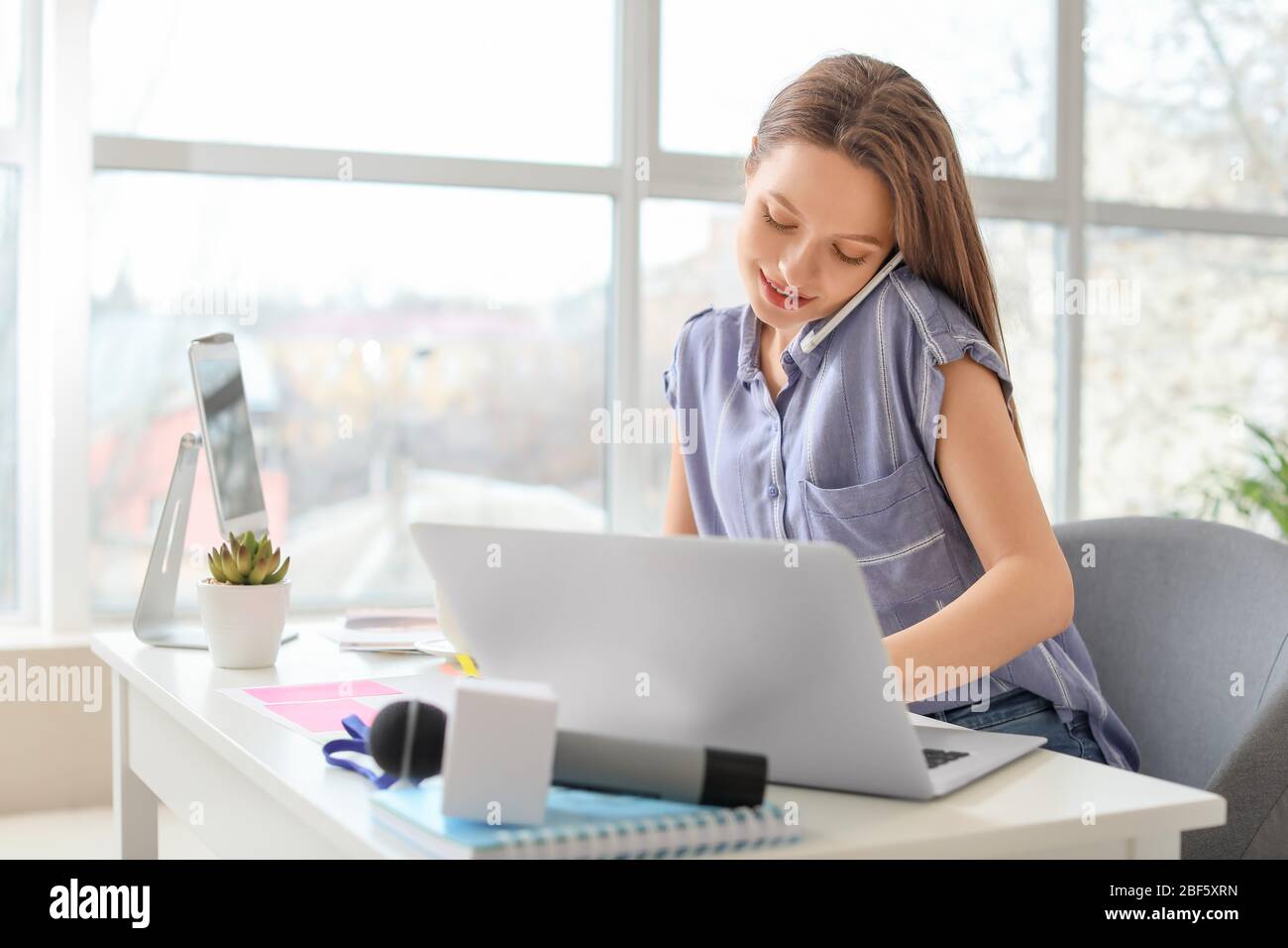 Female journalist working in office Stock Photo - Alamy