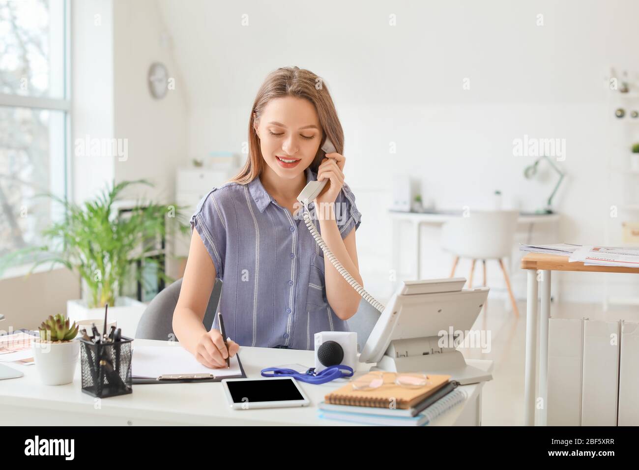 Female journalist working in office Stock Photo - Alamy