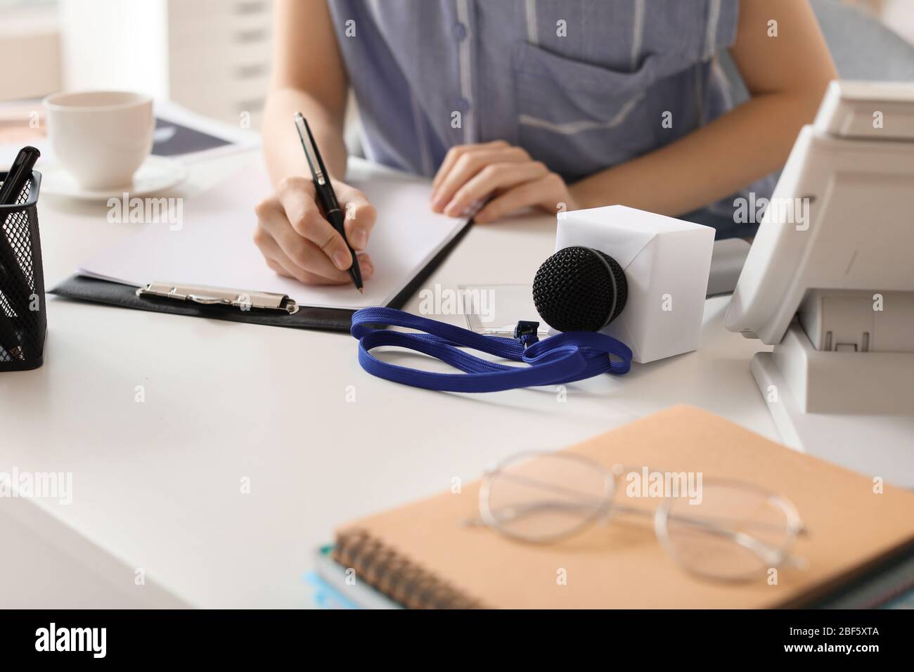 Female journalist working in office Stock Photo - Alamy