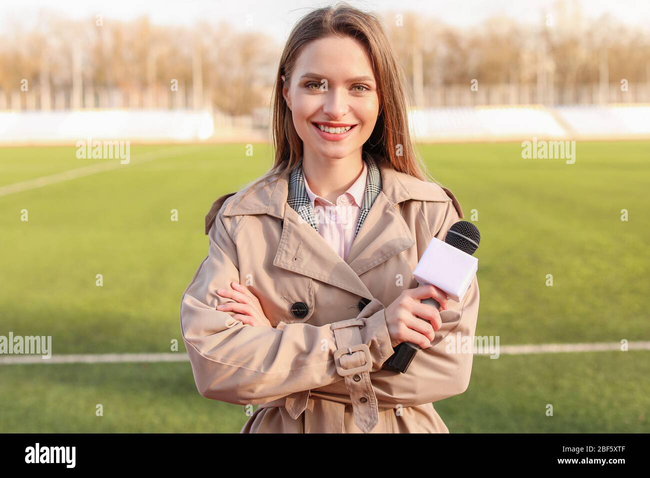 Beautiful reporter with microphone at the stadium Stock Photo - Alamy