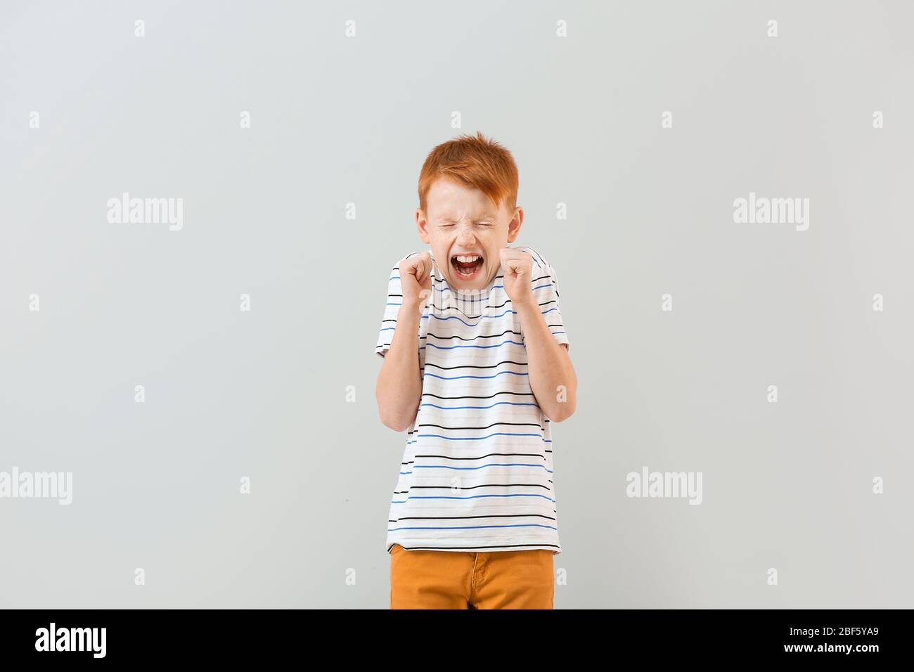 Screaming little boy on light background Stock Photo - Alamy