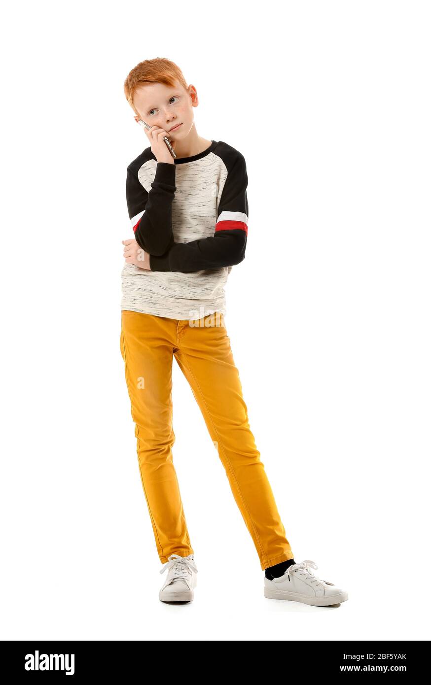 Cute little boy talking by mobile phone on white background Stock Photo ...