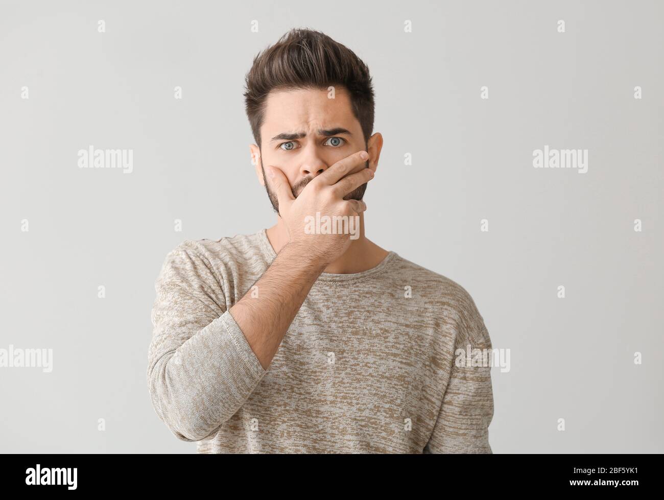 Portrait of worried young man on light background Stock Photo - Alamy