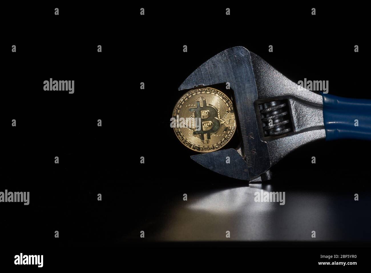 Golden bitcoin on the reflective desk, closeup. Cryptocurrency virtual ...