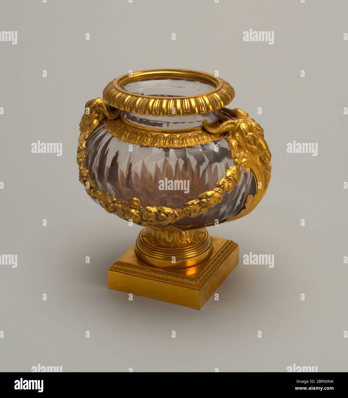 Urn. Deep fluted bombe oval mounted with gadroon lip rim, husk collar ...
