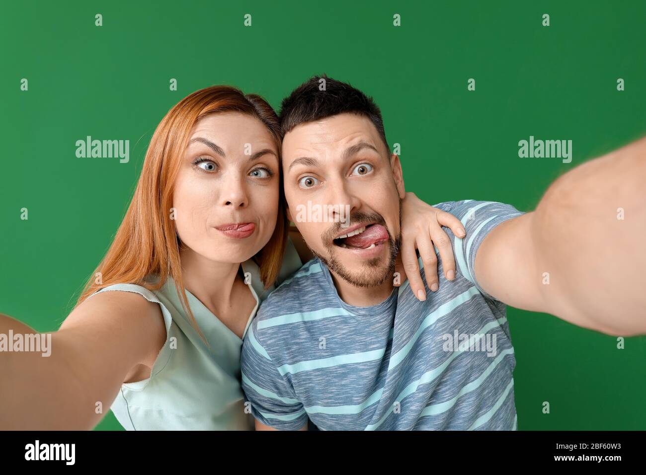 Couple taking selfie on color background Stock Photo - Alamy