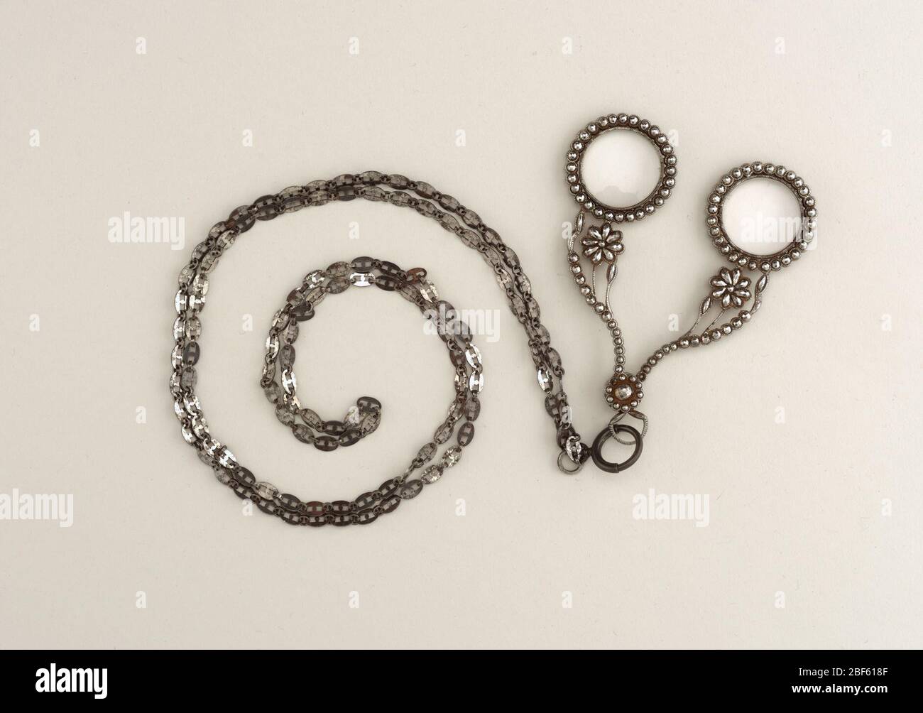 Lorgnon and chain. The glasses, each set at the end of a flowering stem ...