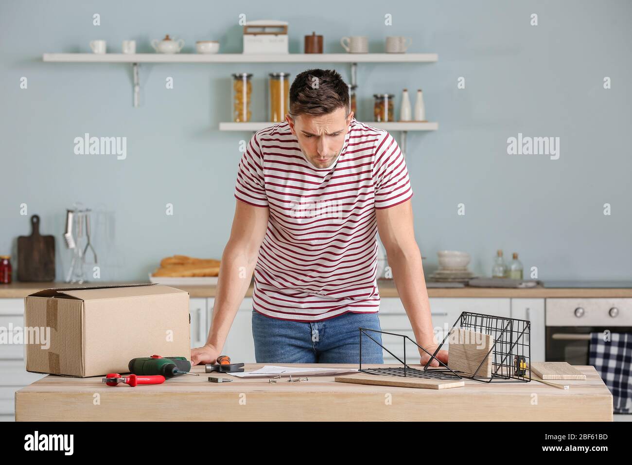 Young man assembling furniture at home Stock Photo - Alamy