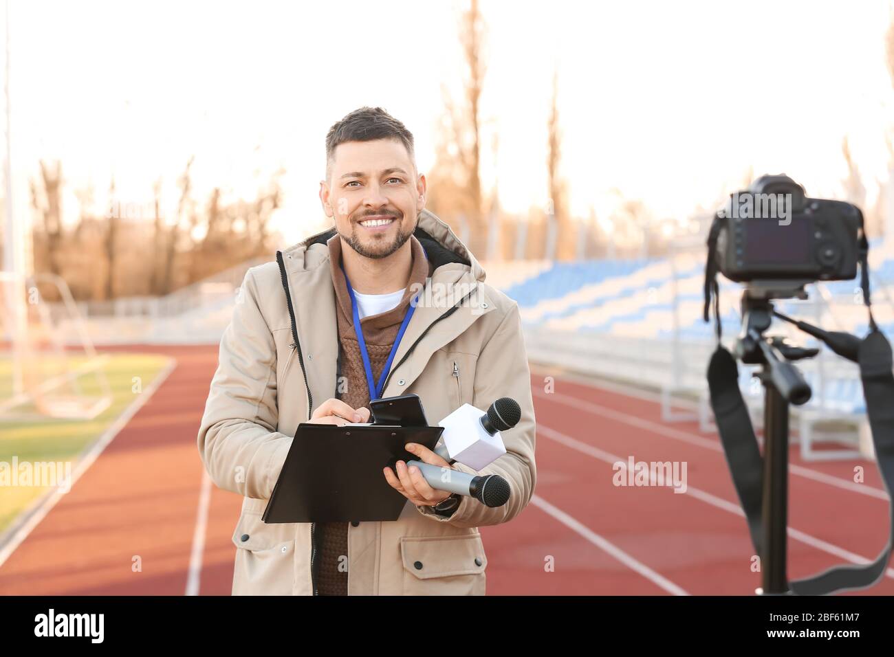 Male reporter with microphones at the stadium Stock Photo - Alamy