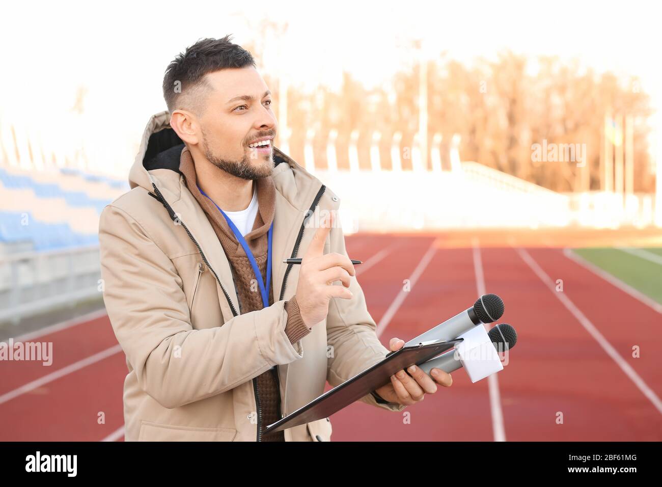 Male reporter with microphones at the stadium Stock Photo - Alamy
