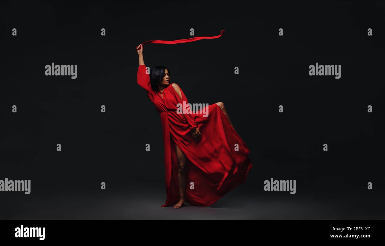 Woman in red dress dancing in studio. Female contemporary dancer ...