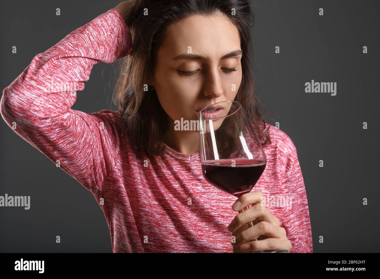 Young drunk woman on dark background. Concept of alcoholism Stock Photo ...