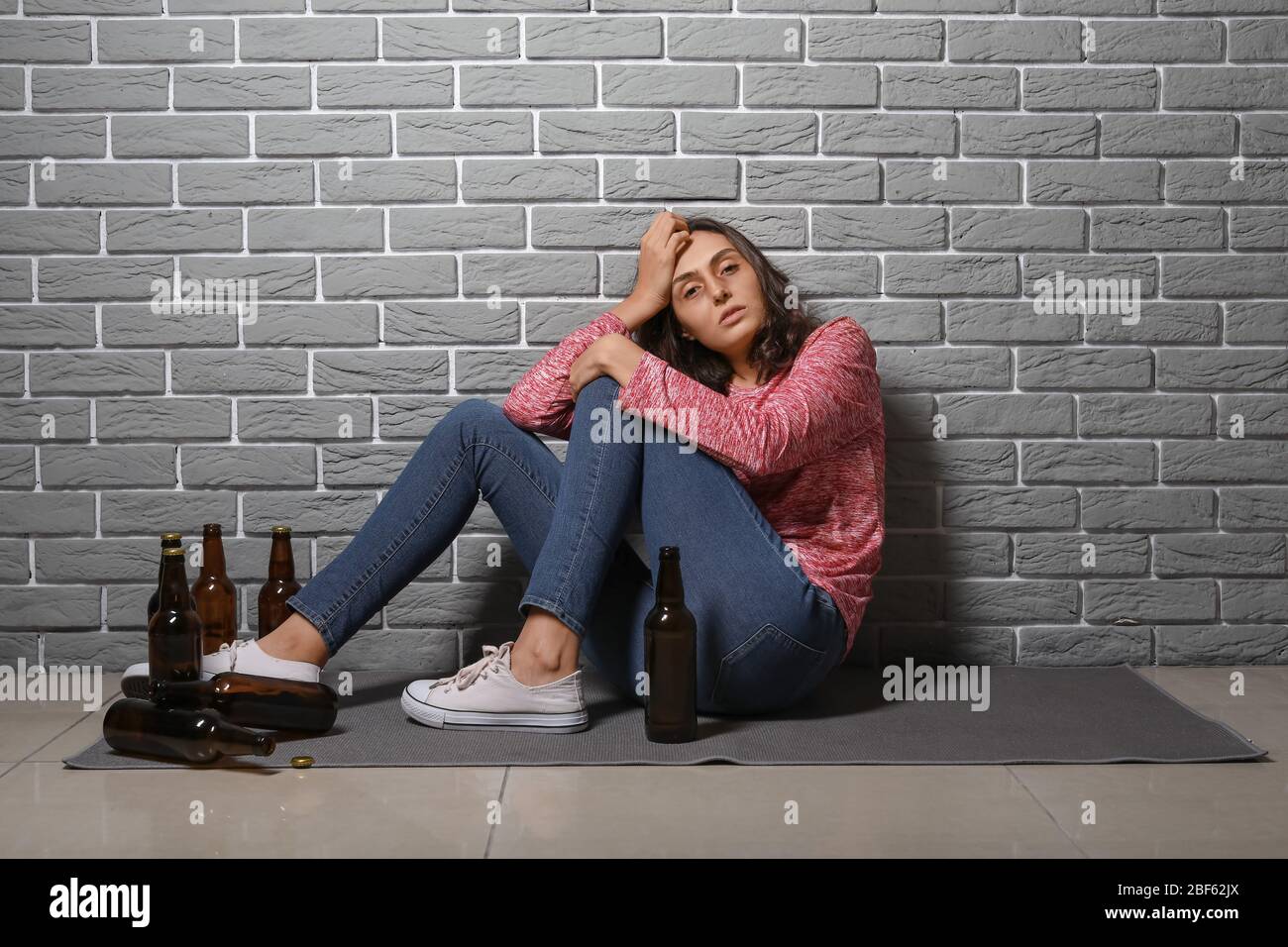 Young drunk woman near brick wall. Concept of alcoholism Stock Photo ...