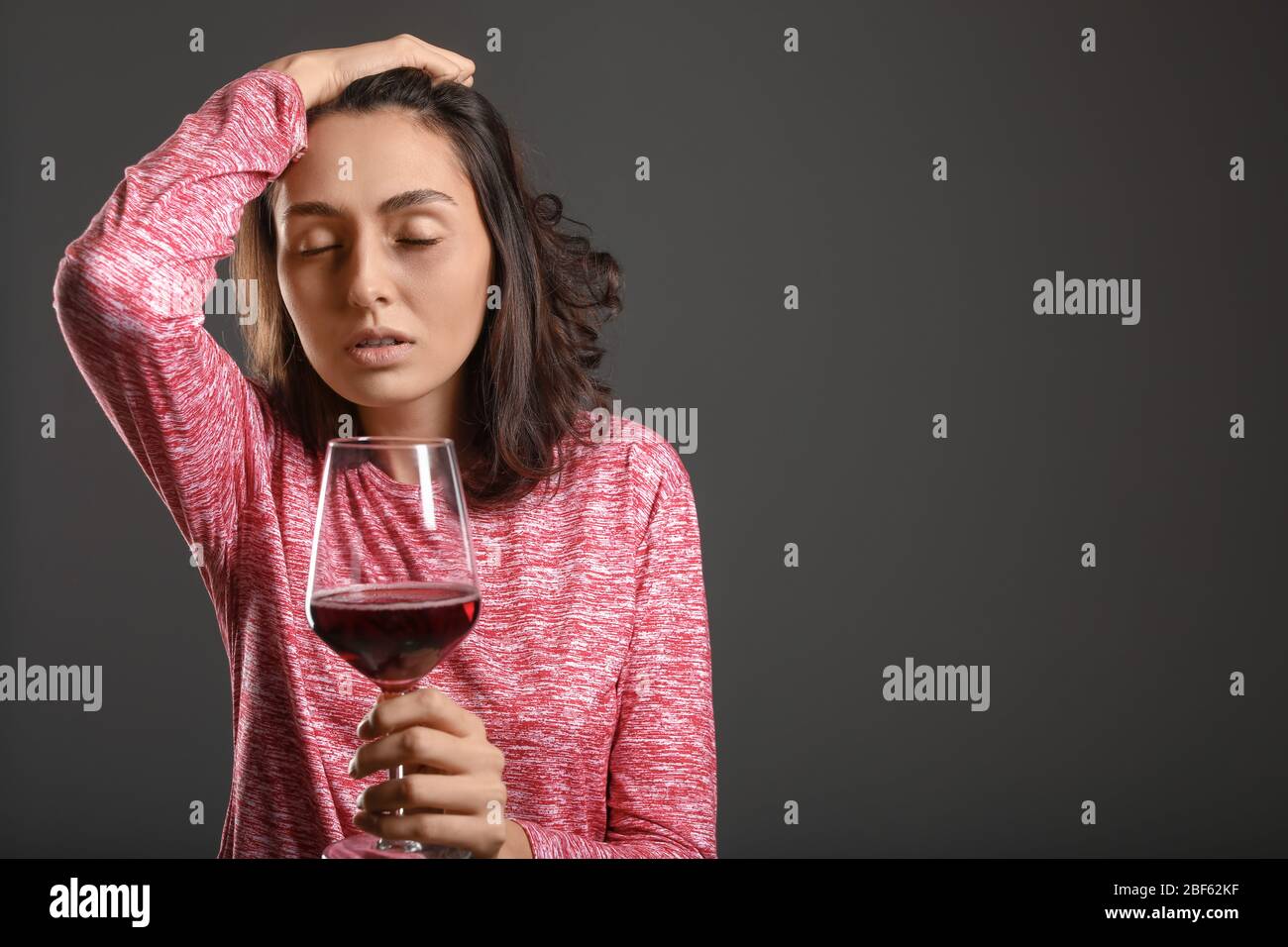 Young drunk woman on dark background. Concept of alcoholism Stock Photo ...