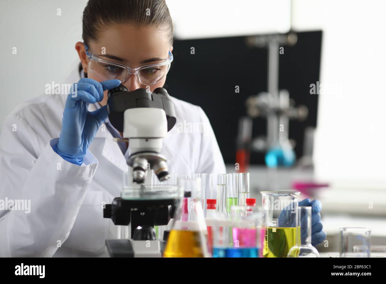 Laboratory assistant using microscope hi-res stock photography and ...