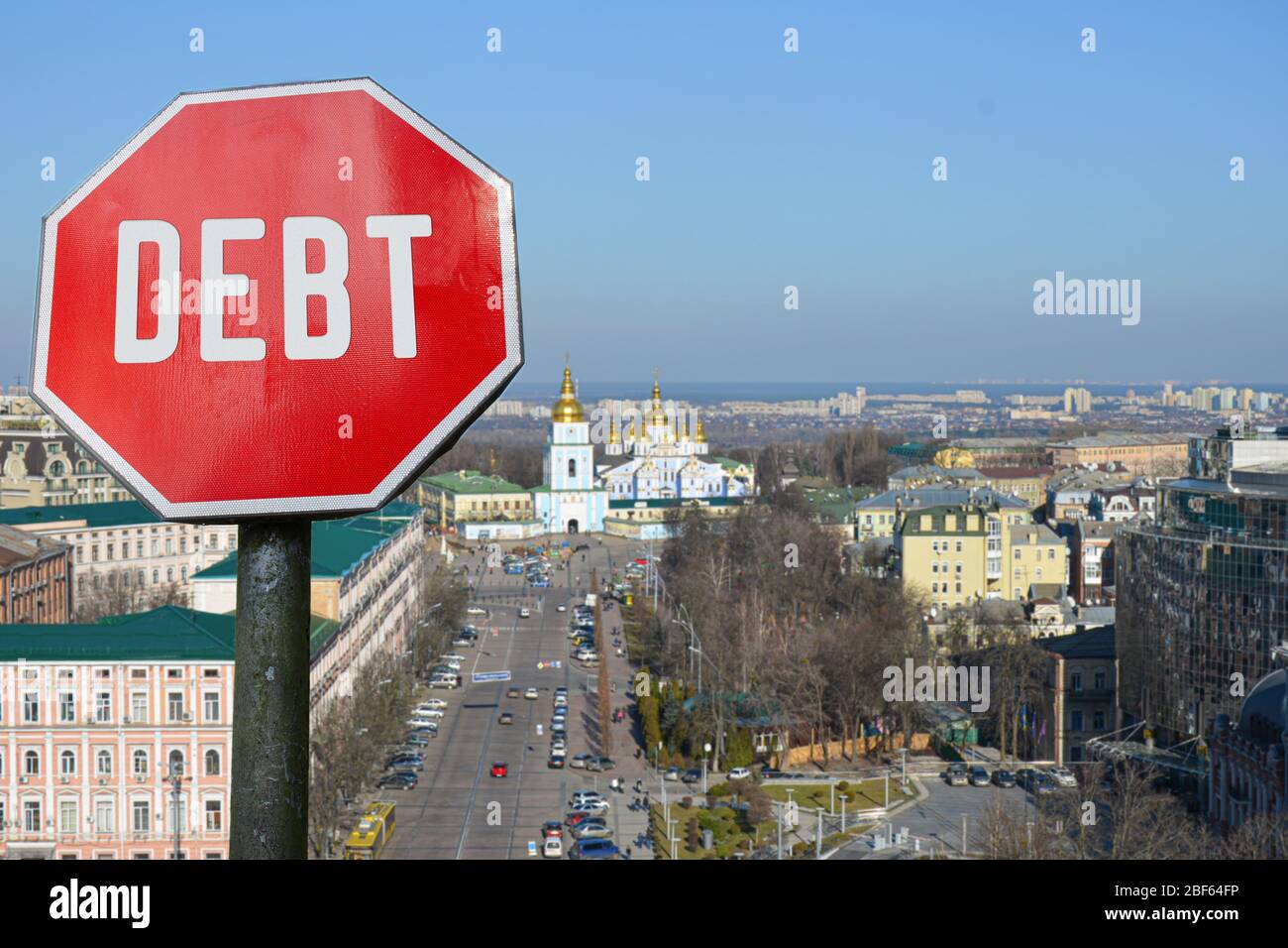 Debt sign on view of Kyiv city center background. Business and economic ...