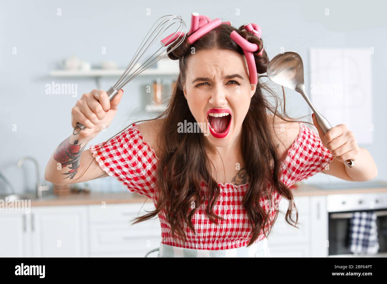 Funny angry housewife in kitchen Stock Photo - Alamy