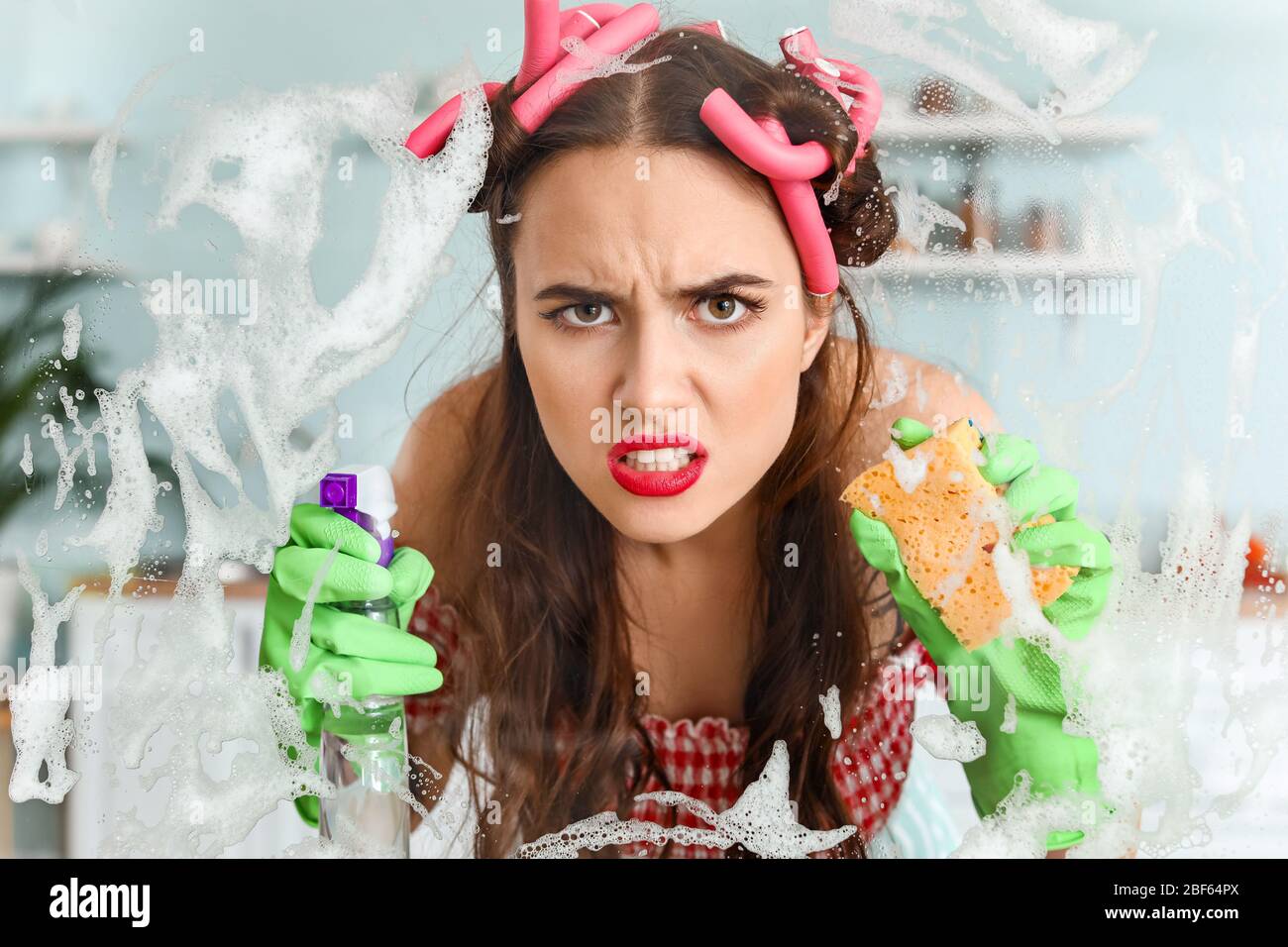 Funny angry housewife cleaning kitchen window Stock Photo - Alamy