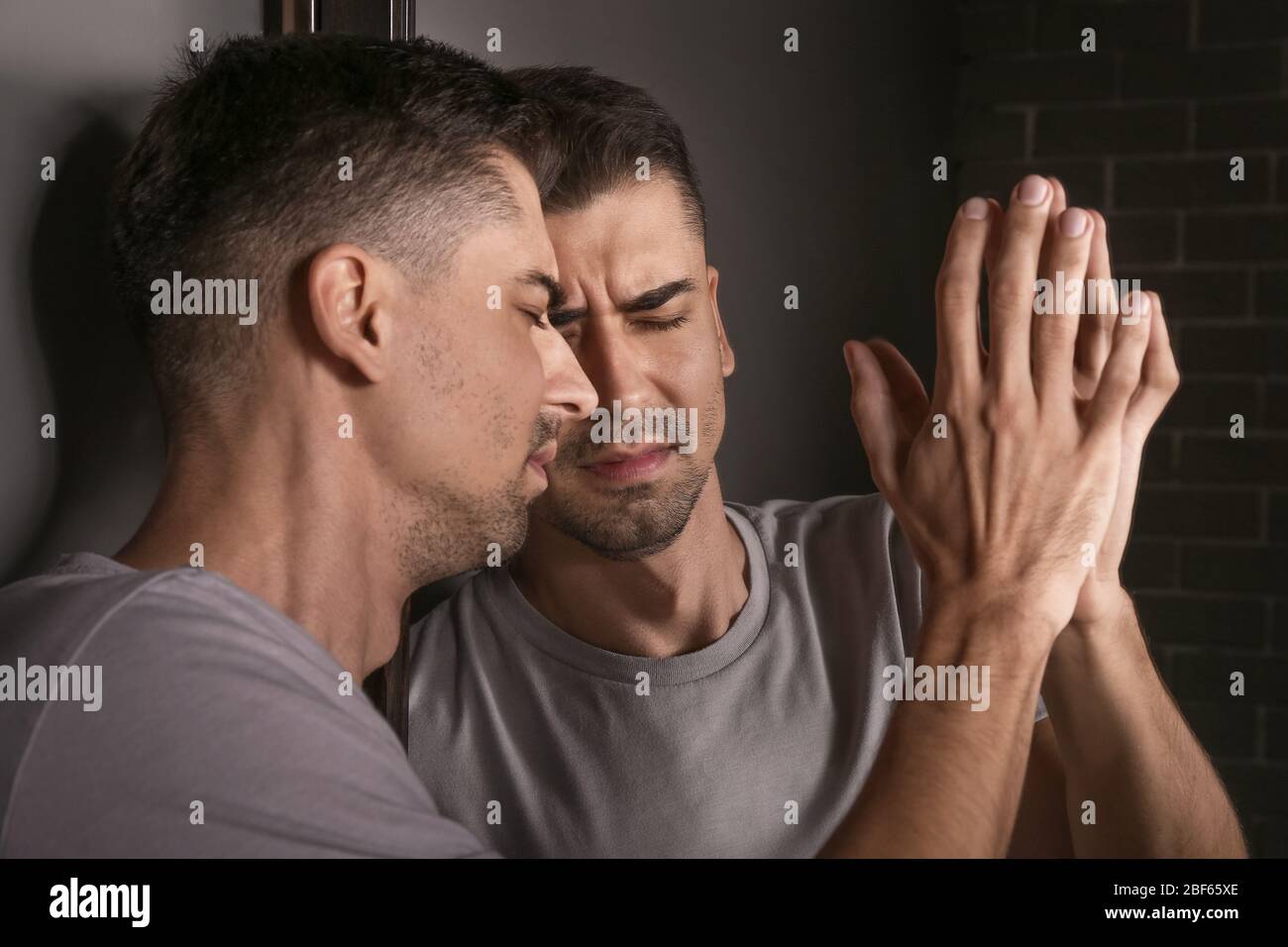 Depressed young man near mirror Stock Photo - Alamy