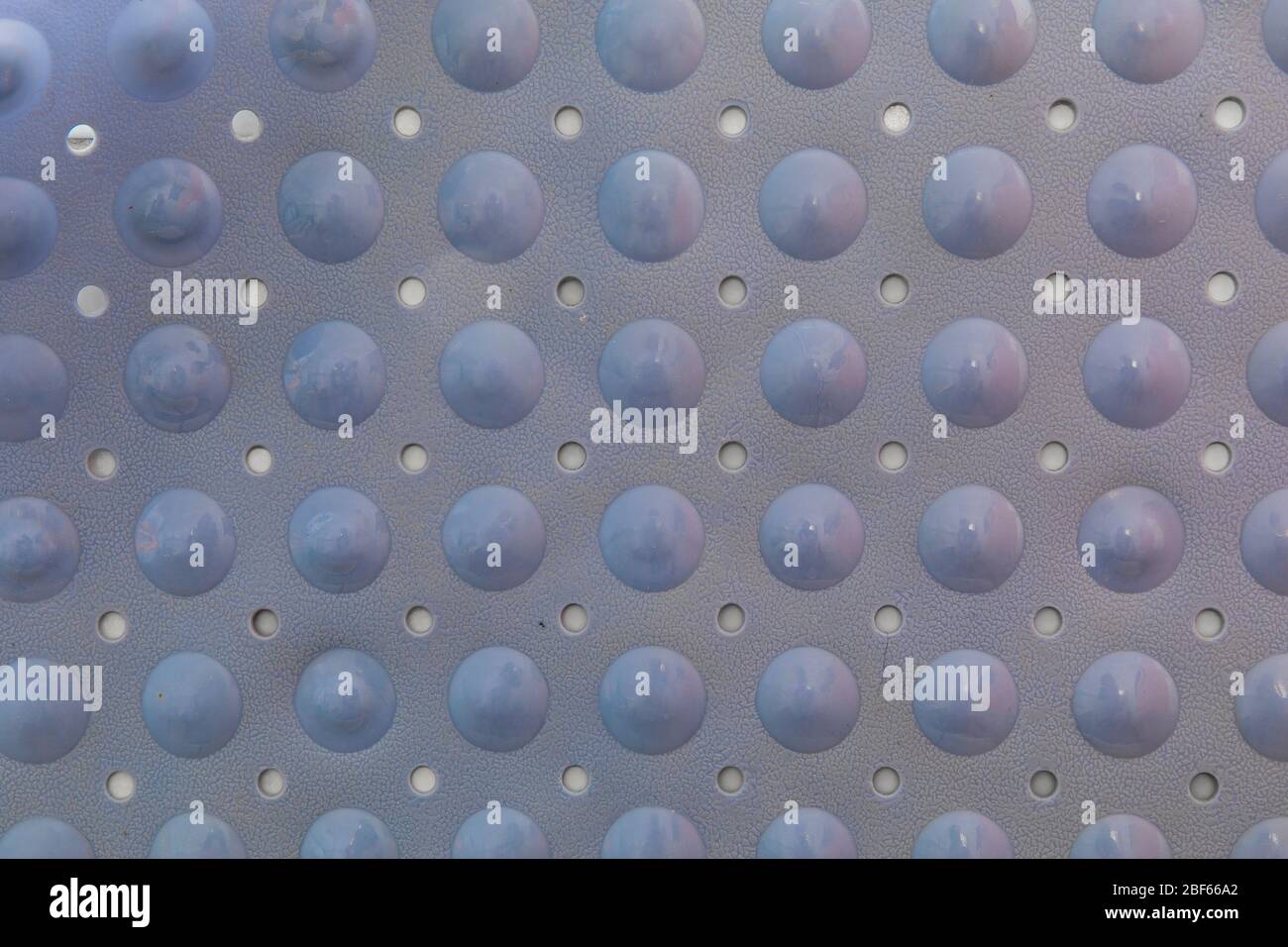 Close-up of a blue plastic bath mat made of bubbles and holes to ...