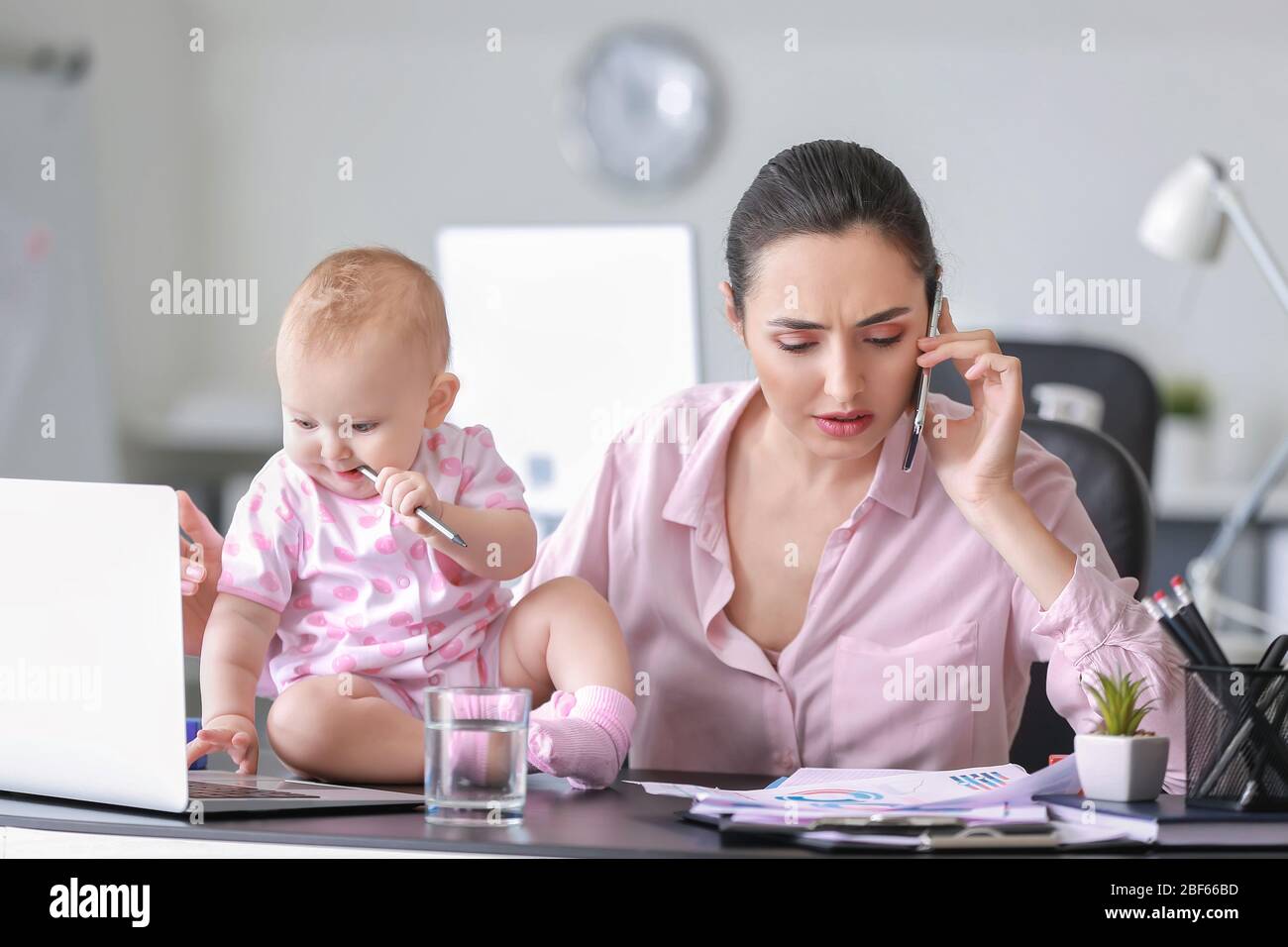 Working mother with her baby in office Stock Photo - Alamy