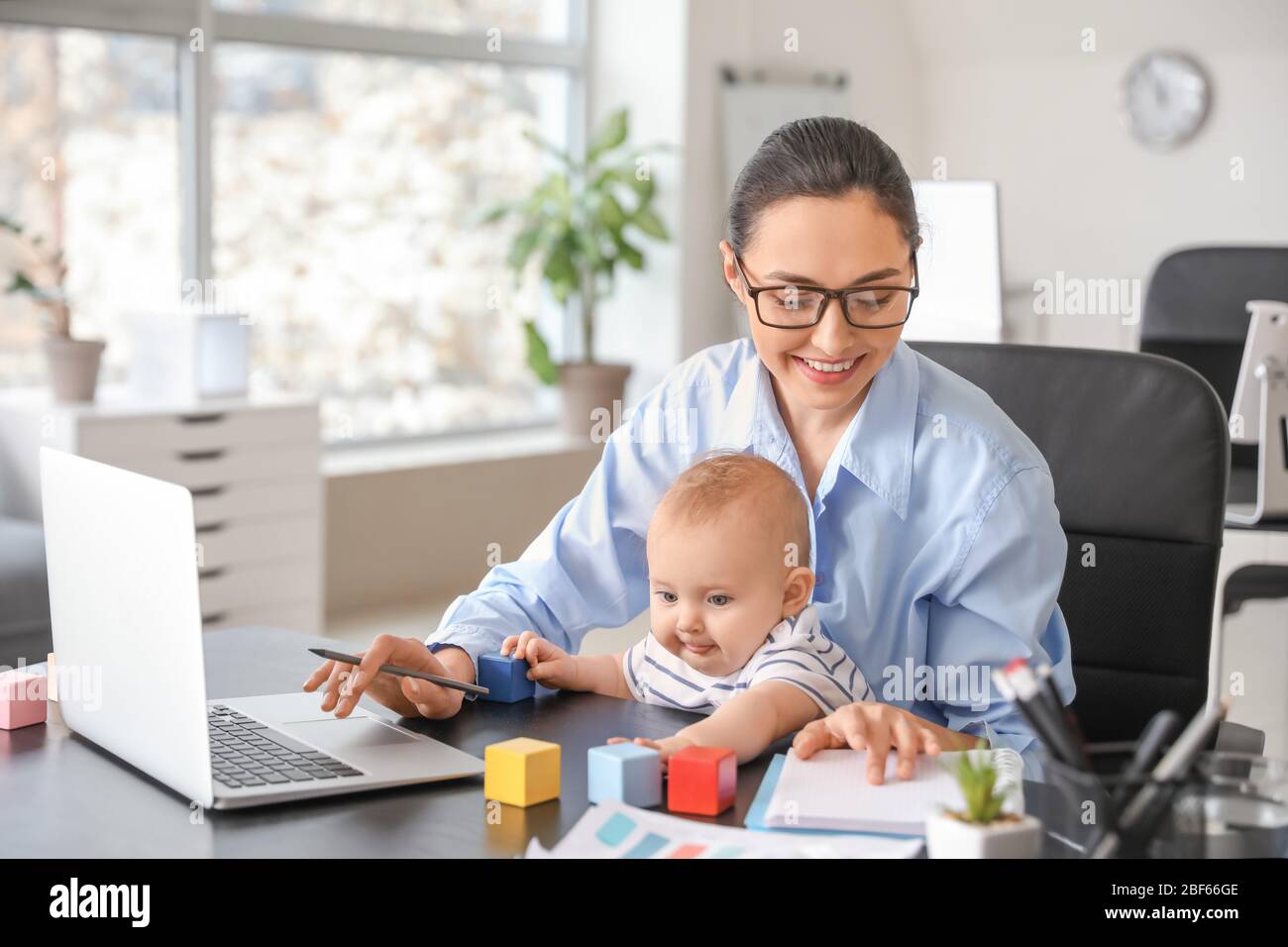 Working mother with her baby in office Stock Photo - Alamy