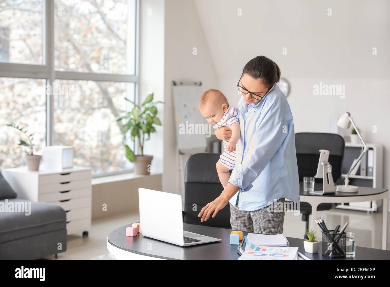 Working mother with her baby in office Stock Photo - Alamy
