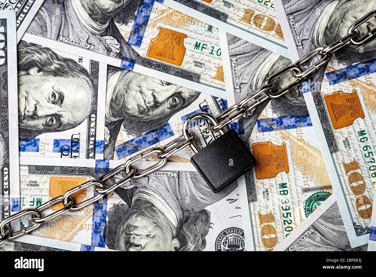 Dollar bills, black lock and metal chain. Money lock or security ...