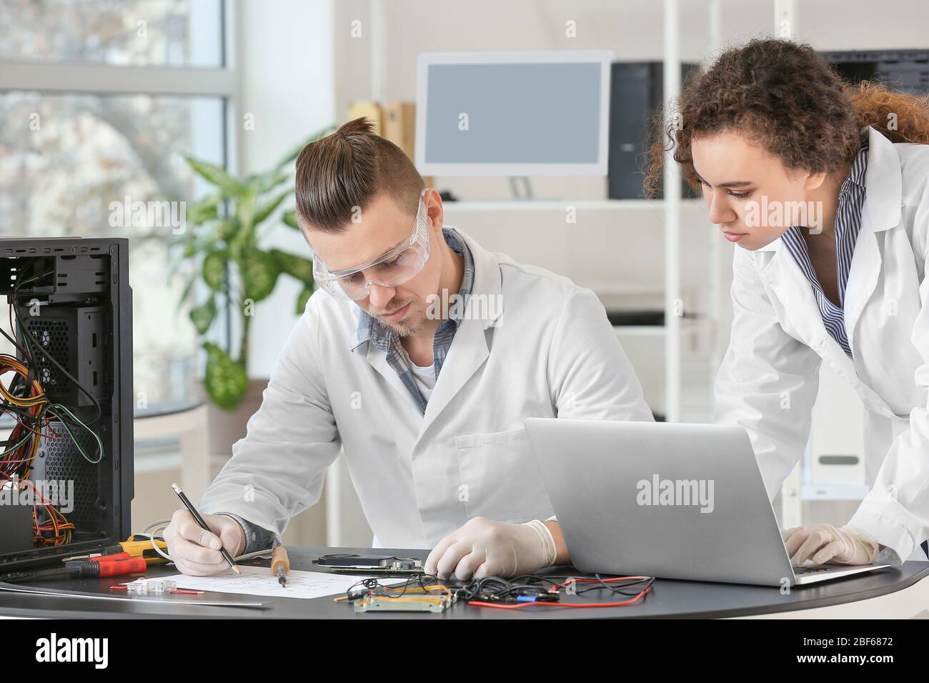 Electronic technicians working in service center Stock Photo - Alamy