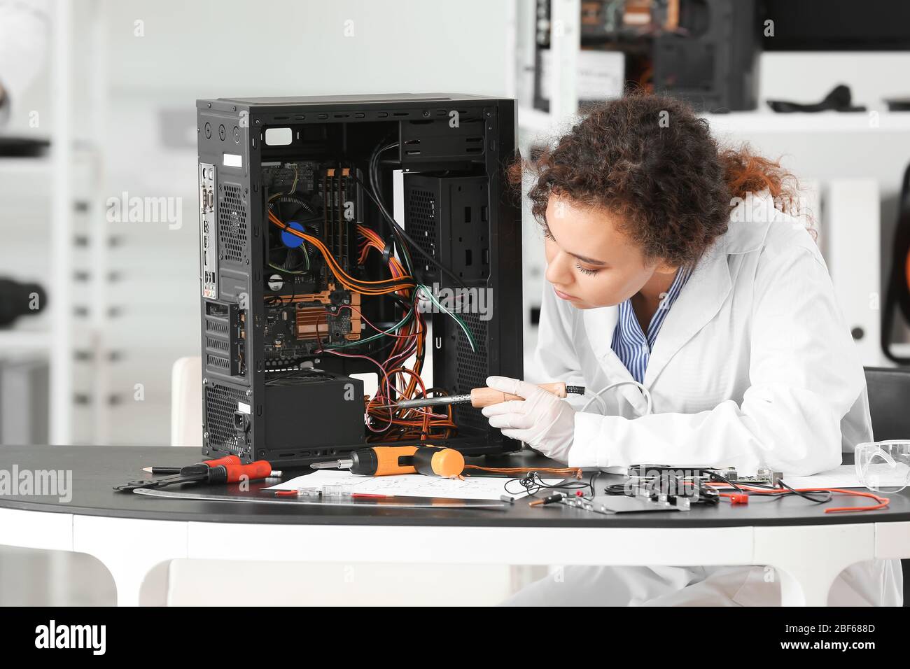 Electronic technician working in service center Stock Photo - Alamy