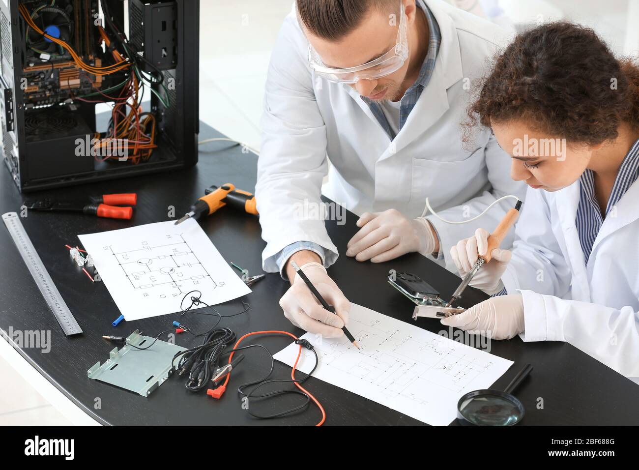 Electronic technicians working in service center Stock Photo - Alamy