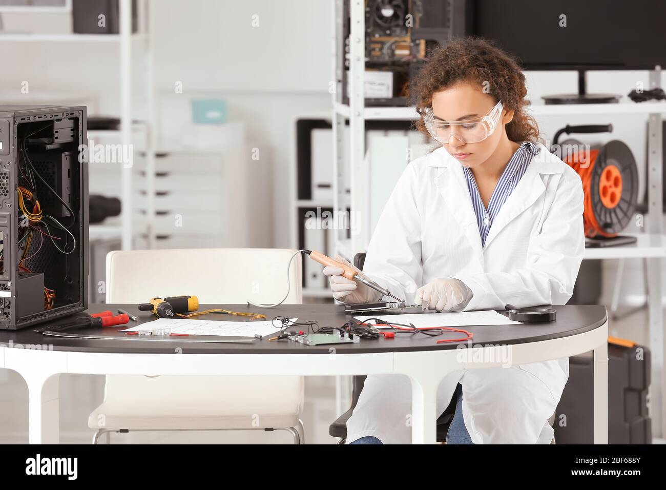Electronic technician working in service center Stock Photo - Alamy